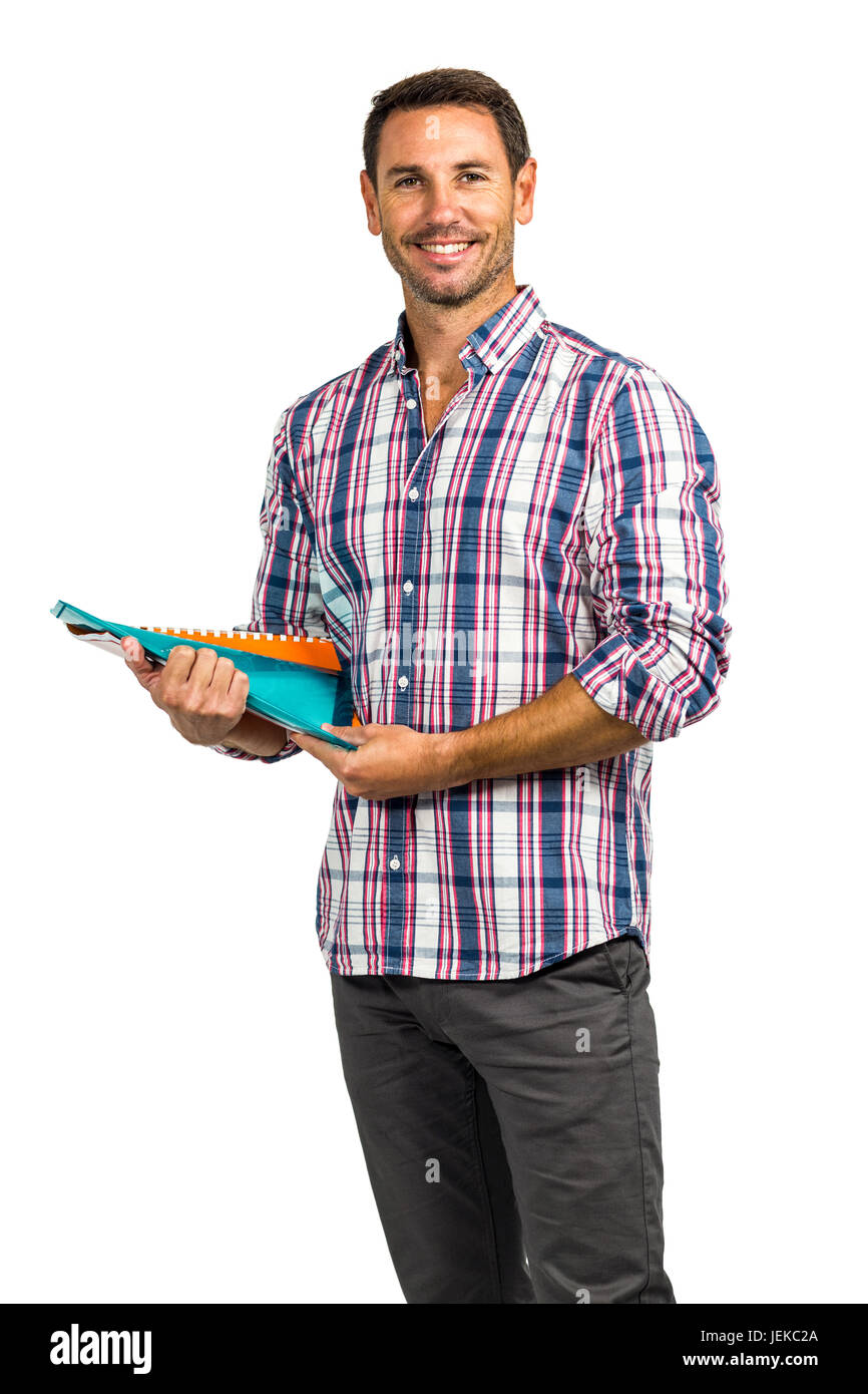 Smiling man standing while holding notepads Stock Photo - Alamy