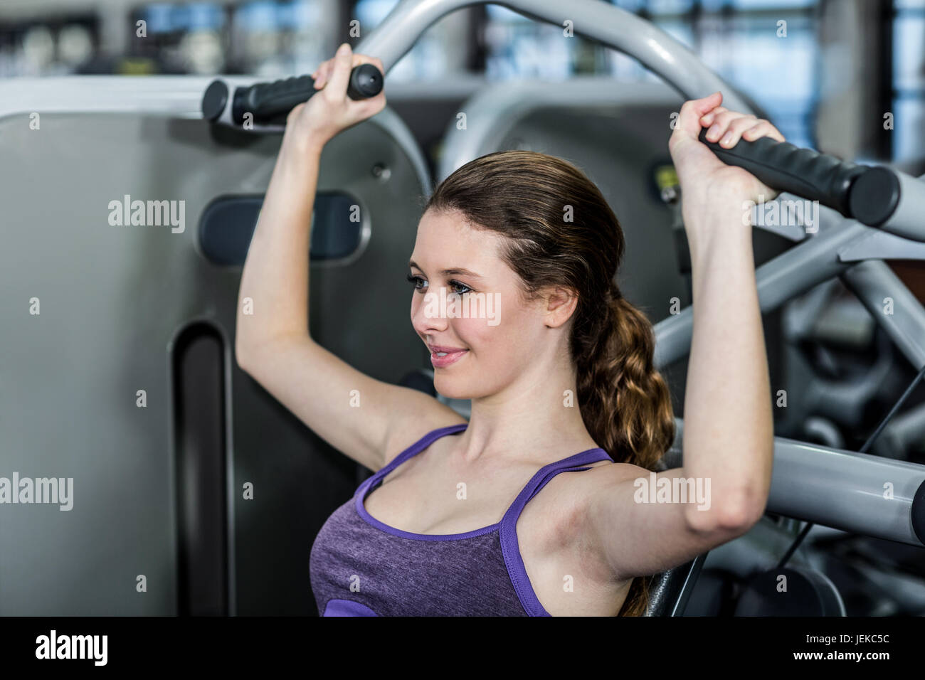Fit woman using exercise machine Stock Photo - Alamy