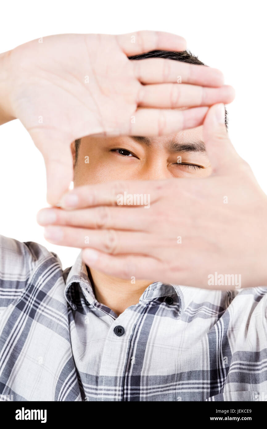 Portrait of man looking through finger frame Stock Photo - Alamy