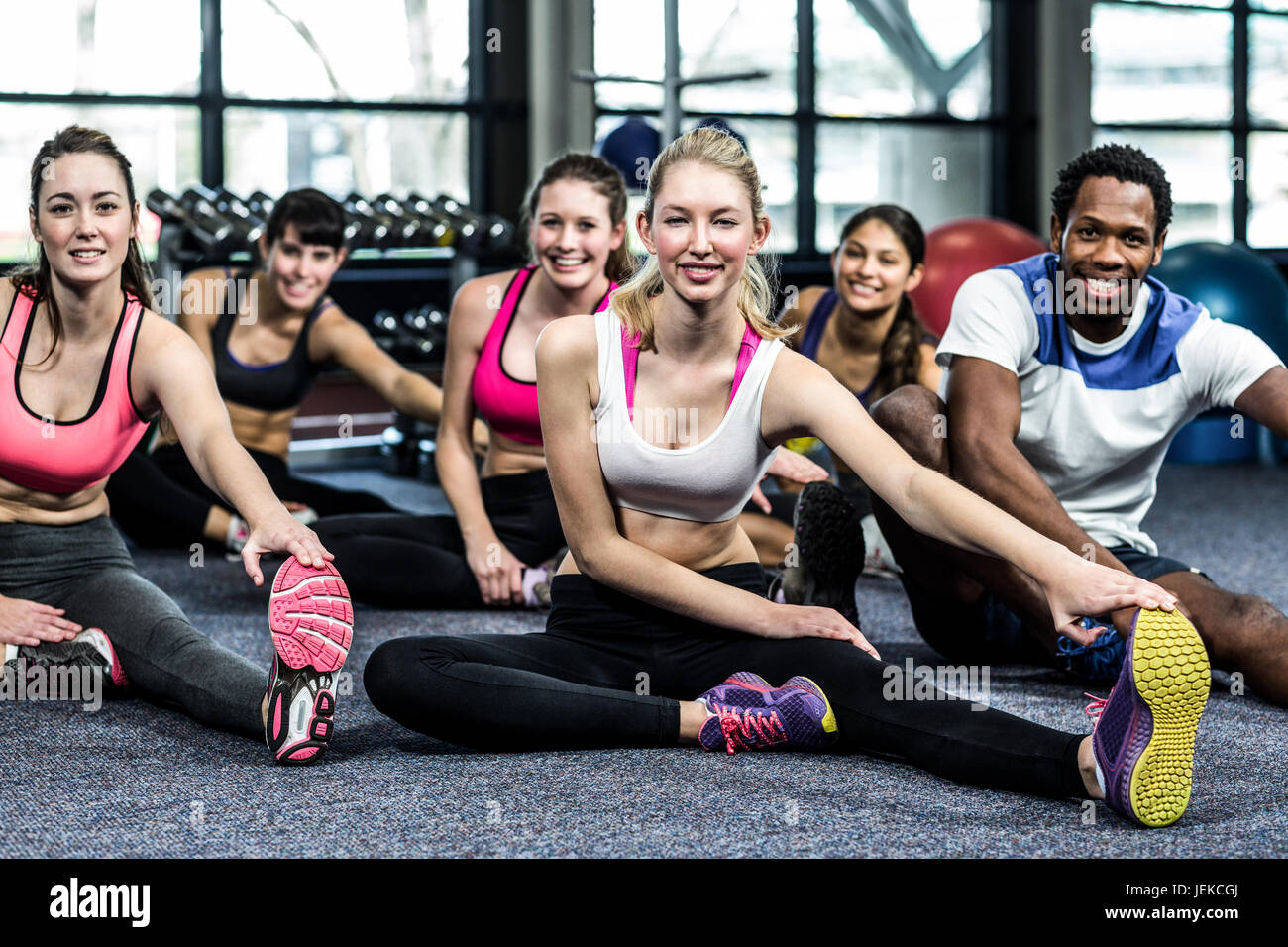 Fit smiling group doing stretching Stock Photo - Alamy