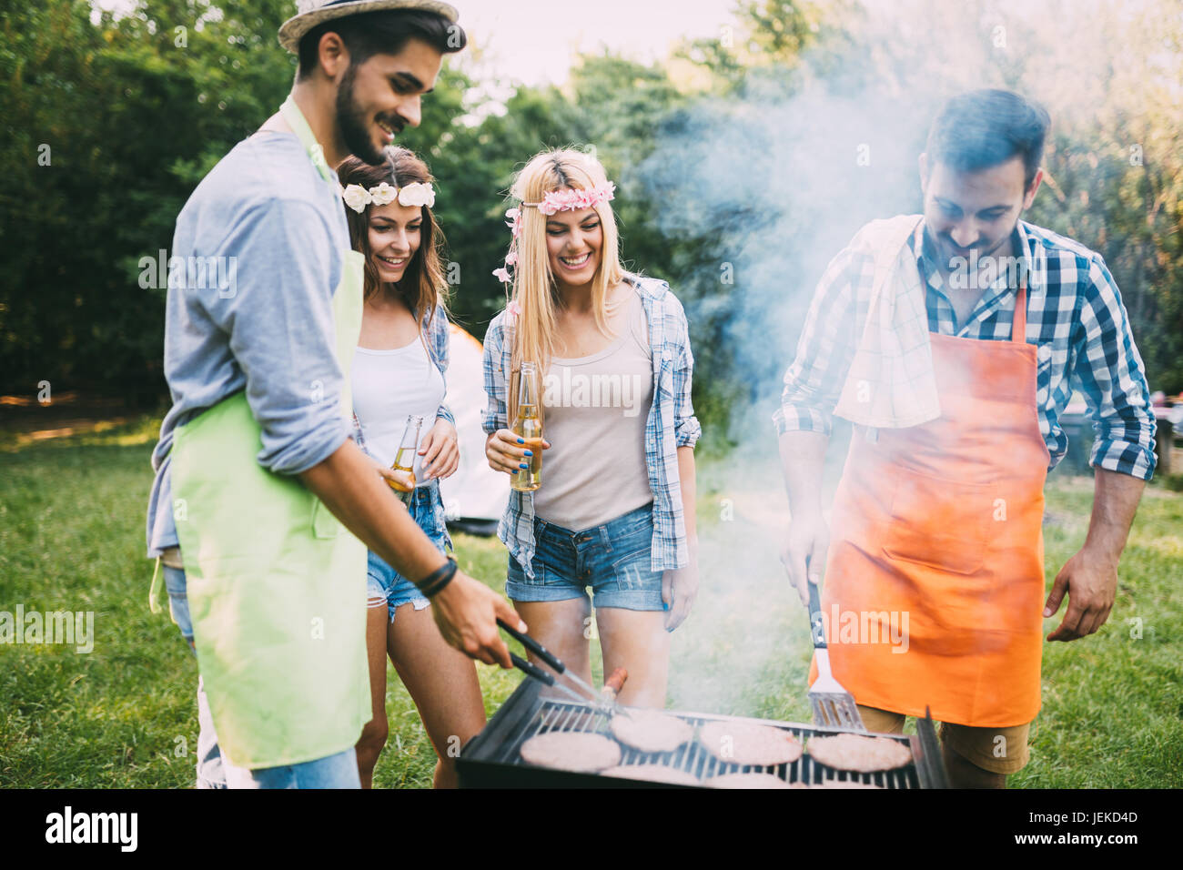 Cheerful friends spending time in nature and having barbecue Stock ...