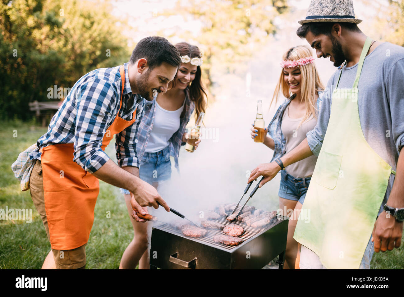 Cheerful friends spending time in nature and having barbecue Stock ...