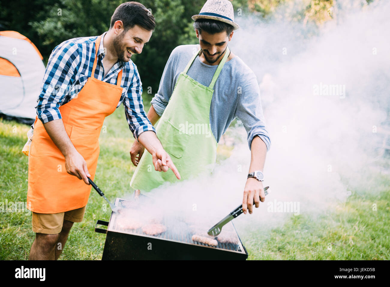 Cheerful friends spending time in nature and having barbecue Stock ...