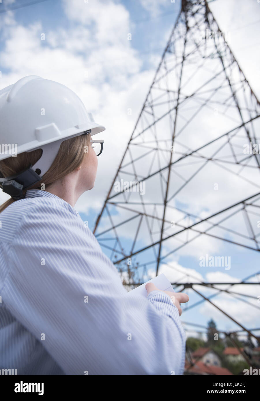 Female engineer looking at power lines Stock Photo - Alamy