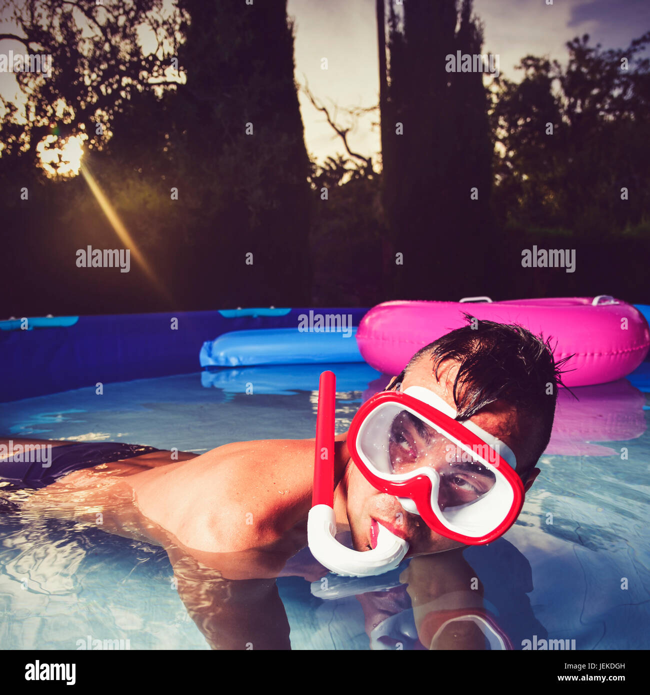 young caucasian man wearing a diving mask and a snorkel, swimming in a ...