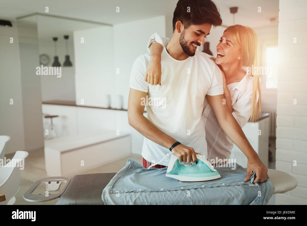 Young beautiful woman hugging her attractive boyfriend while he uses ...