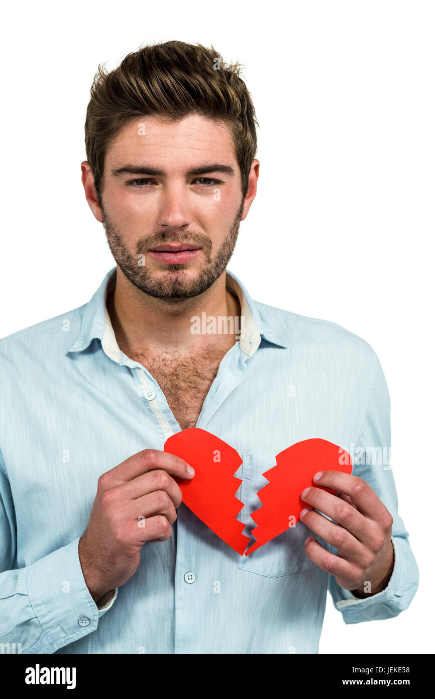 Sad man holding heart halves Stock Photo - Alamy
