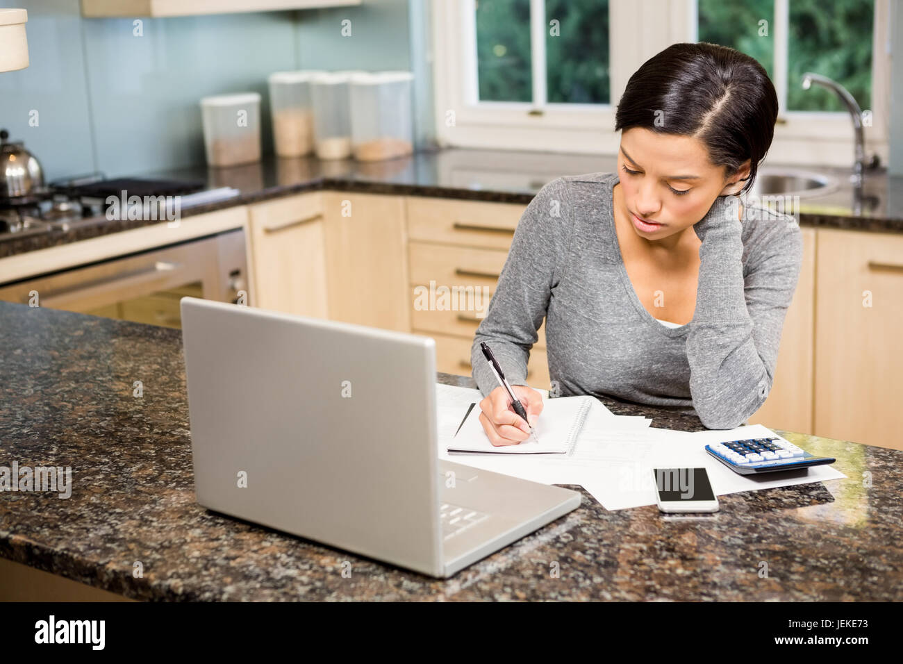 Worried brunette counting bills Stock Photo - Alamy