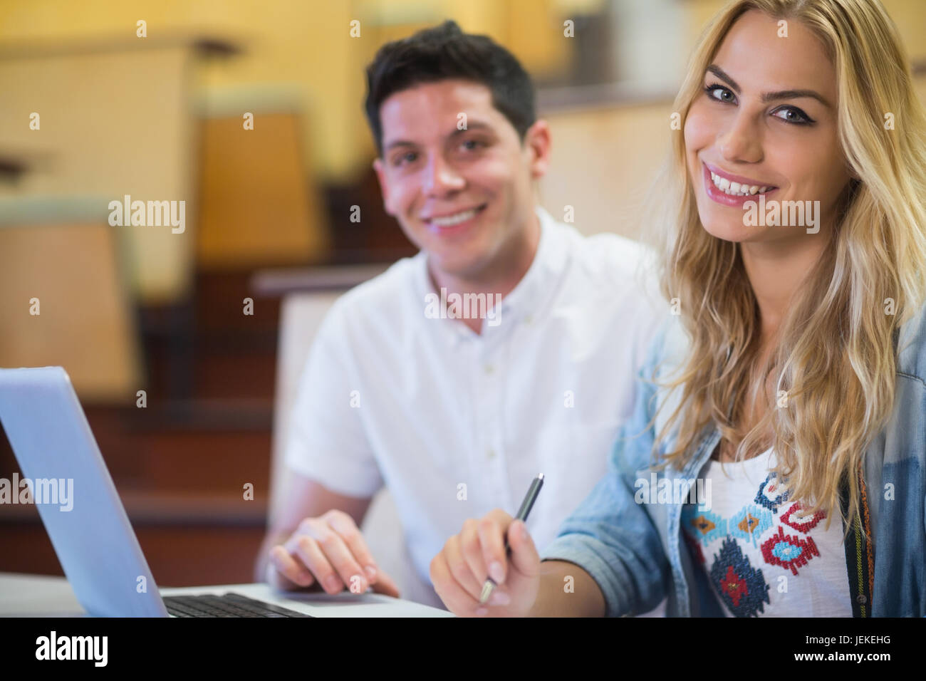 Smiling college students using laptop Stock Photo - Alamy
