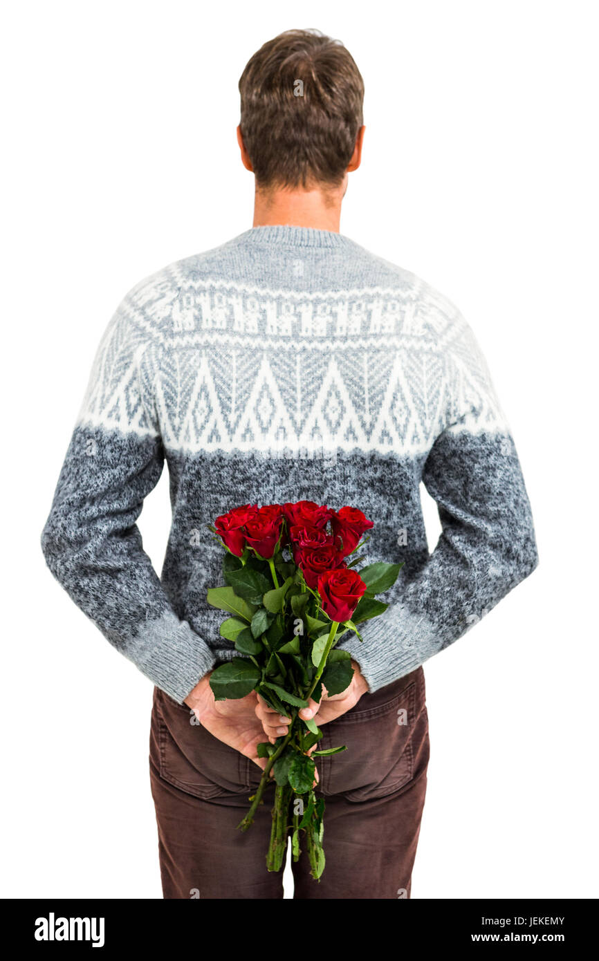 Rear view of man hiding red roses Stock Photo - Alamy