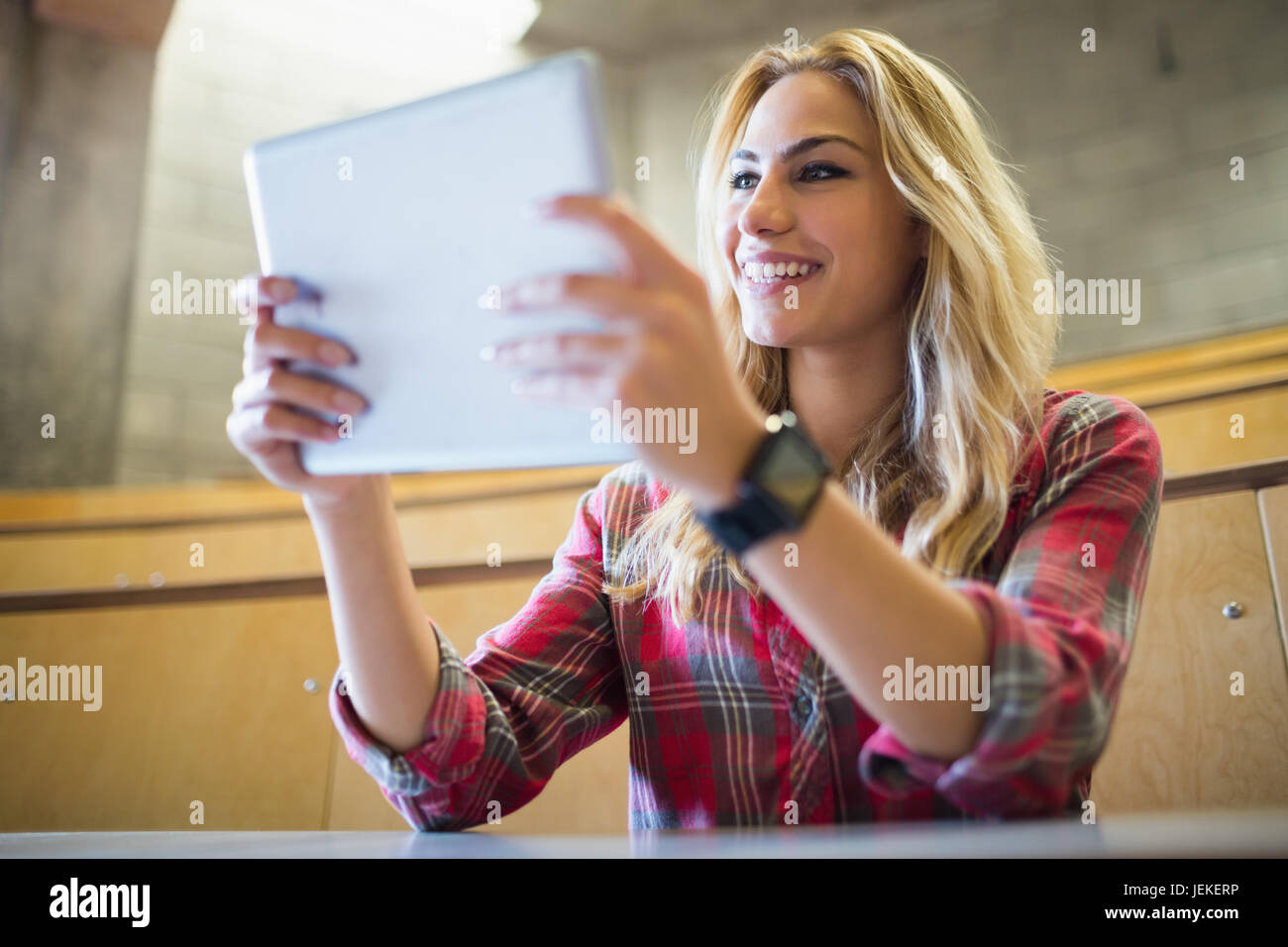 Smiling female student using tablet Stock Photo - Alamy
