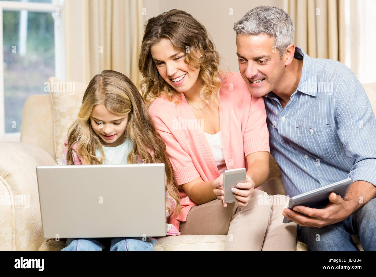 Happy family looking at laptop screen Stock Photo - Alamy