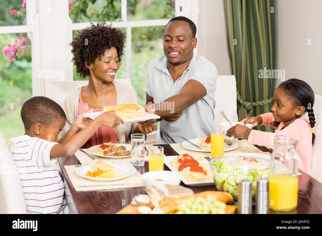 Happy family eating together Stock Photo - Alamy