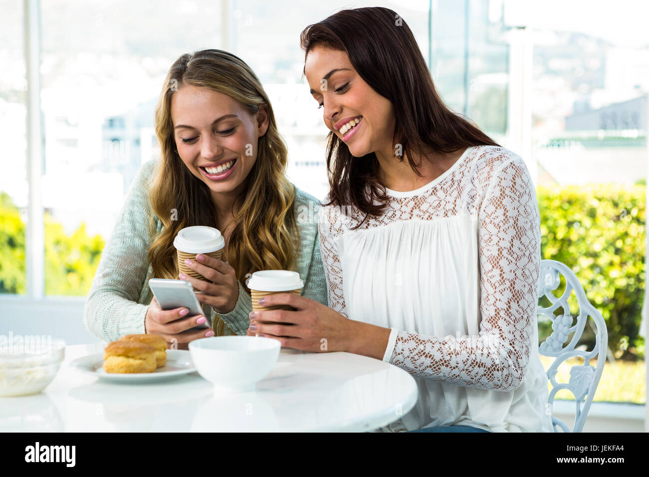 two girls use a phone Stock Photo - Alamy