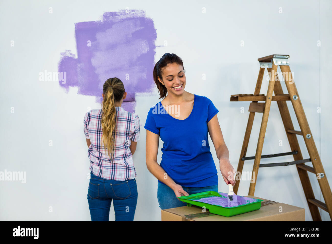 Friends painting a wall Stock Photo - Alamy