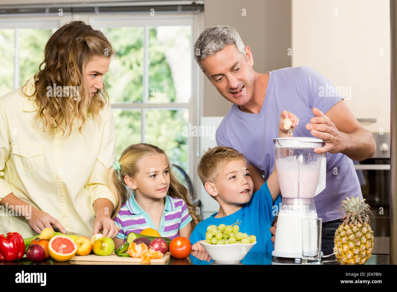 Happy family preparing healthy smoothie Stock Photo - Alamy