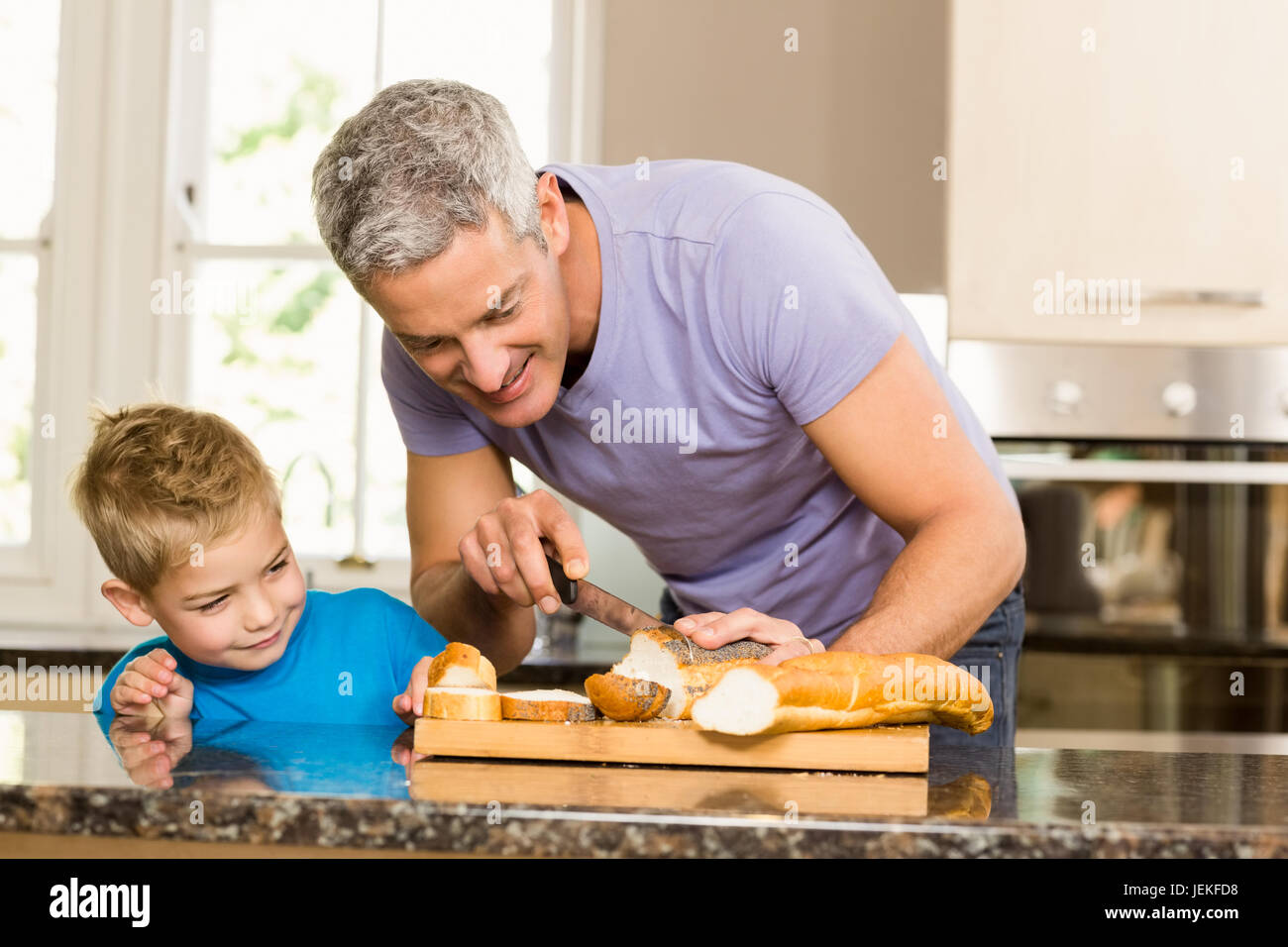Happy father slicing bread Stock Photo - Alamy