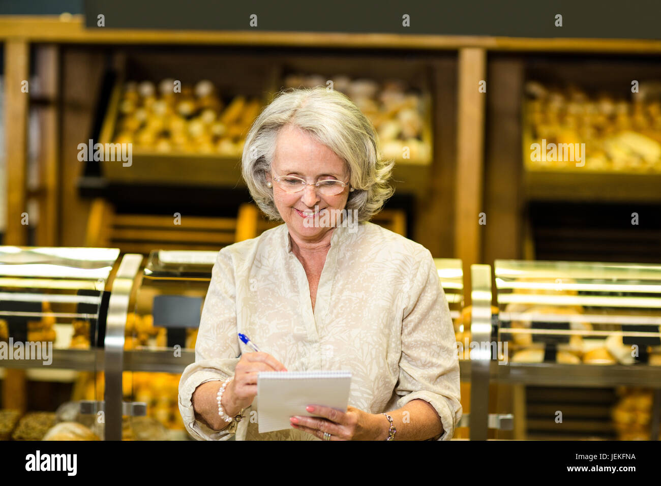 Smiling senior woman checking list Stock Photo - Alamy
