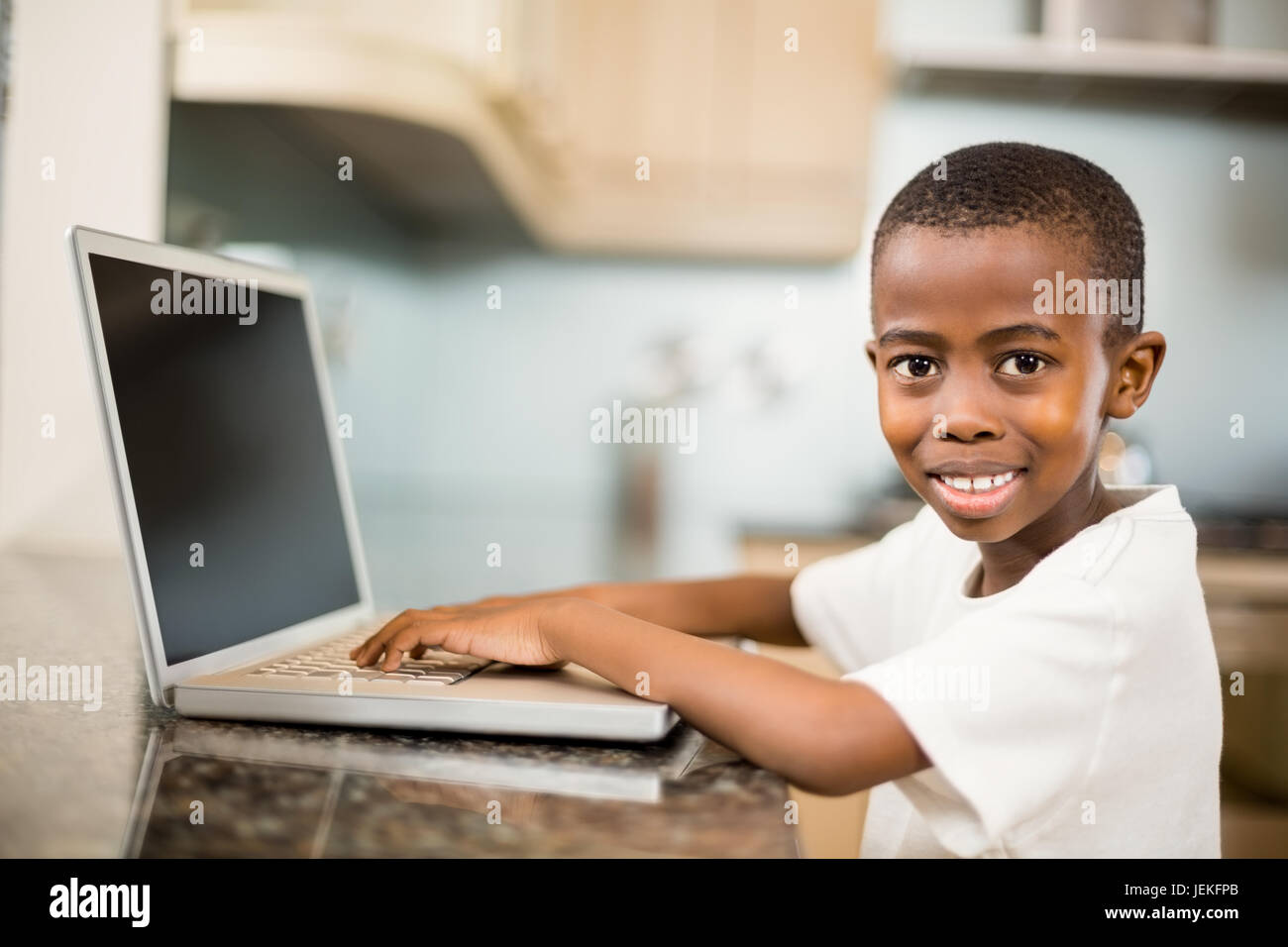Smiling boy using laptop Stock Photo - Alamy