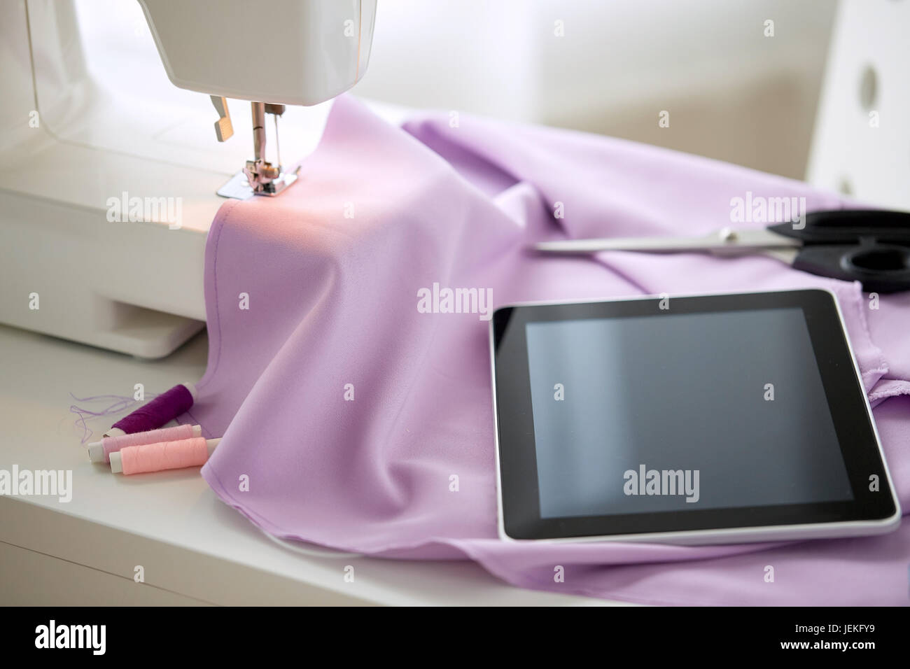 sewing machine, tablet pc, fabric and threads Stock Photo - Alamy