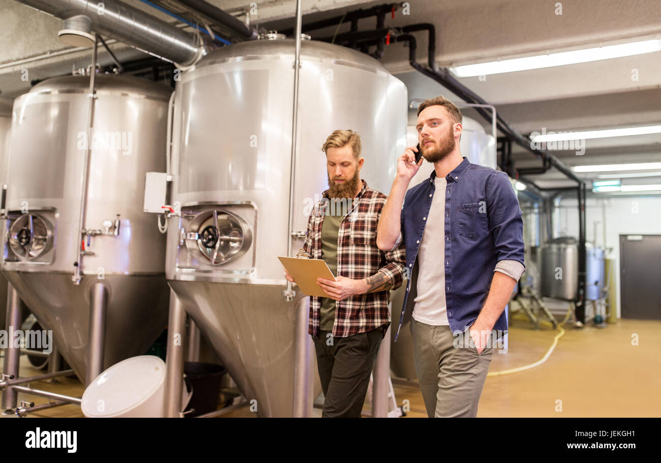 men working at craft brewery or beer plant Stock Photo - Alamy
