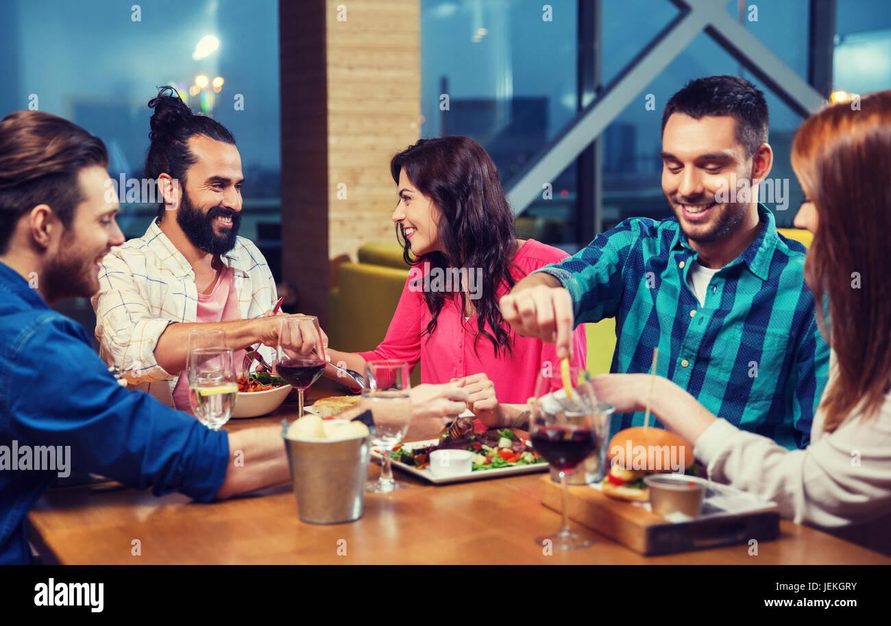 friends eating and tasting food at restaurant Stock Photo - Alamy