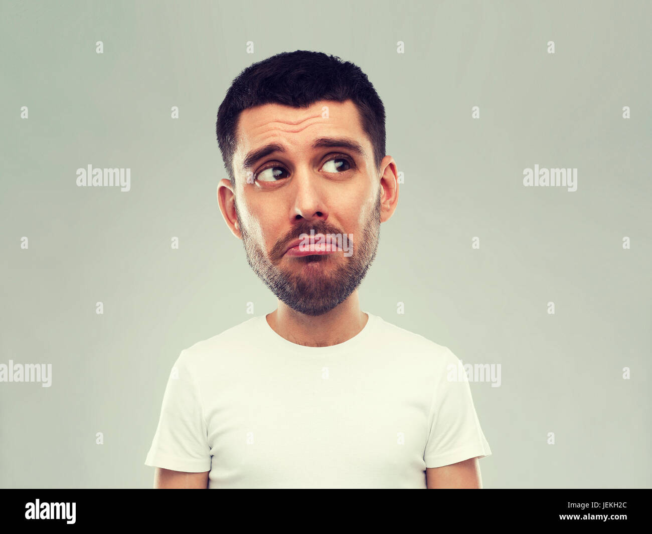unhappy young man over gray background Stock Photo - Alamy