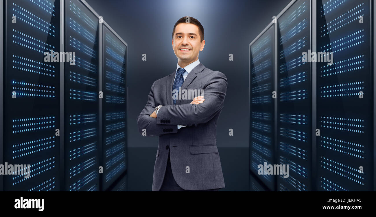 smiling businessman over server room background Stock Photo - Alamy