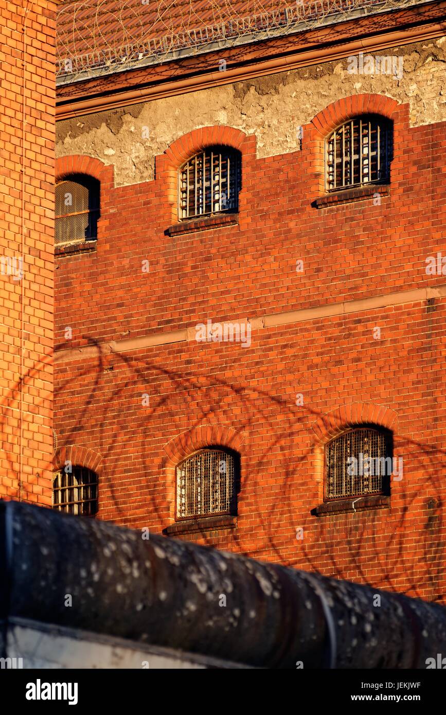 The outside view of an old and abandoned jail in Berlin during sunset ...
