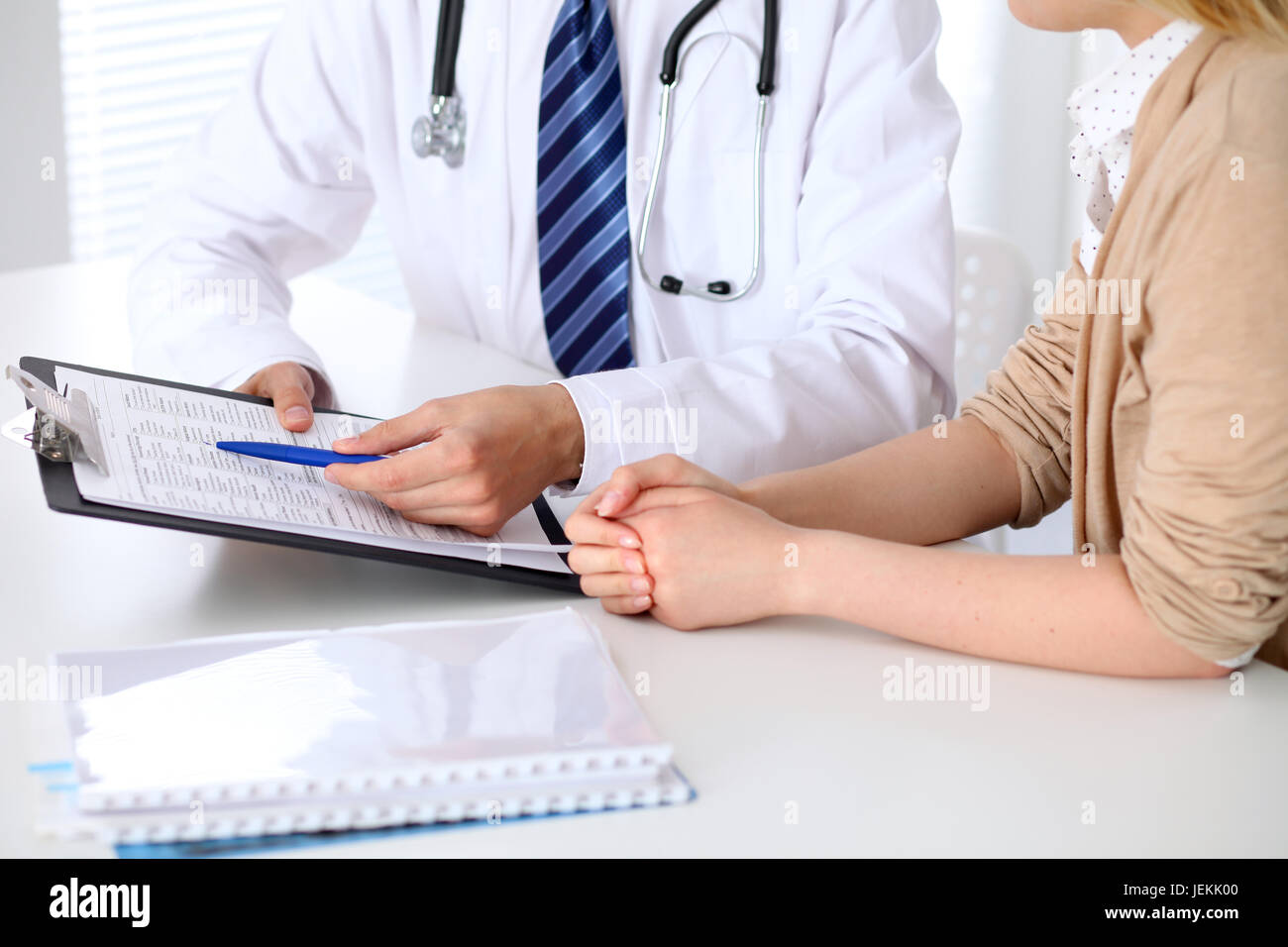 Close-up of a doctor man holding application form while consulting ...