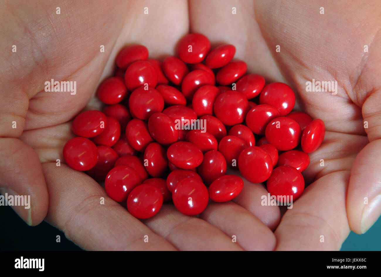 A double handful of red tables (pills) held in female hands Stock Photo ...