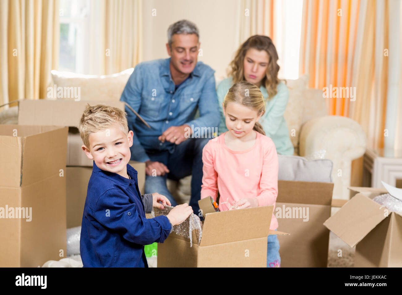 Cute family opening boxes Stock Photo - Alamy