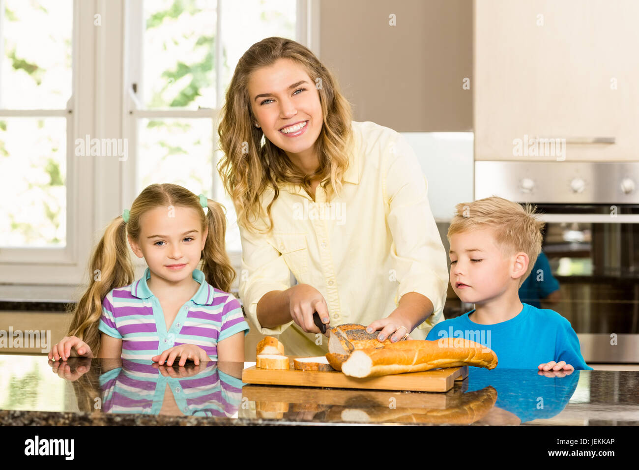 Happy family slicing bread Stock Photo - Alamy