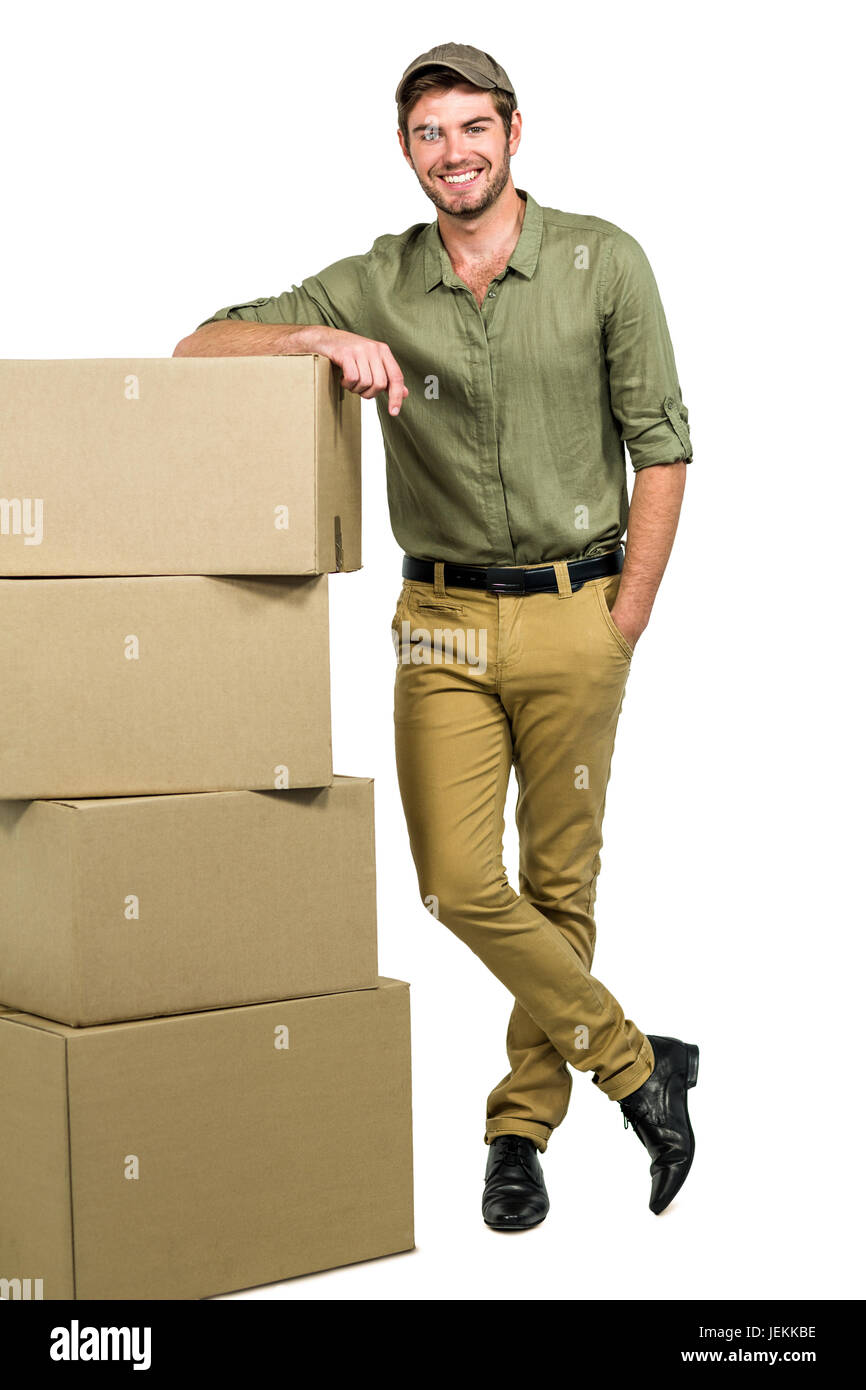 Handsome postman standing by cardboard boxes Stock Photo - Alamy