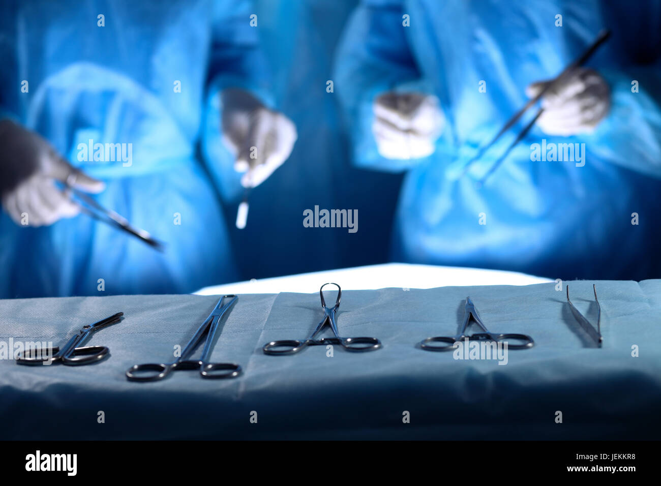 Surgical tools lying on the table while group of surgeons at background ...