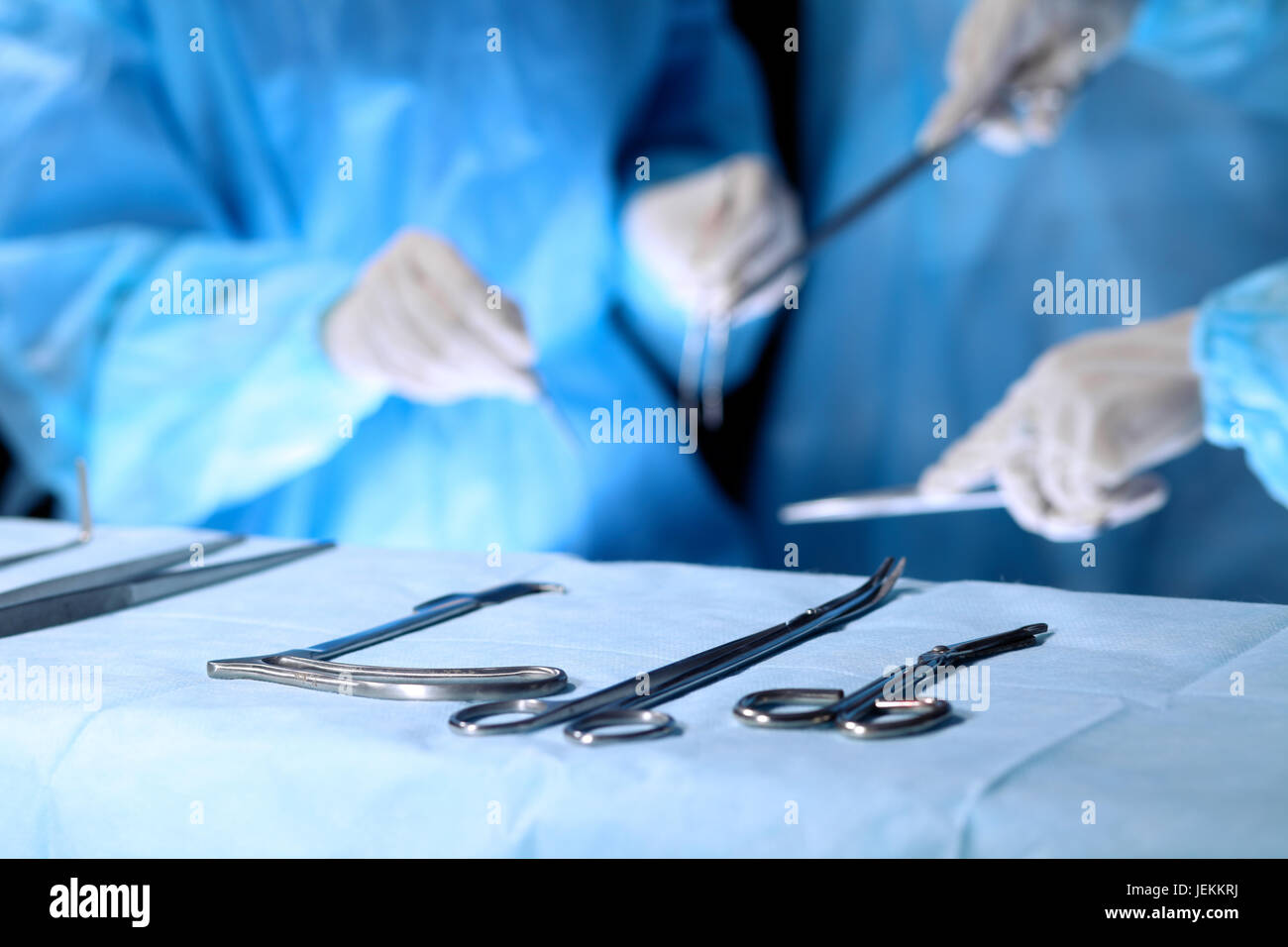 Surgical tools lying on the table while group of surgeons at background ...
