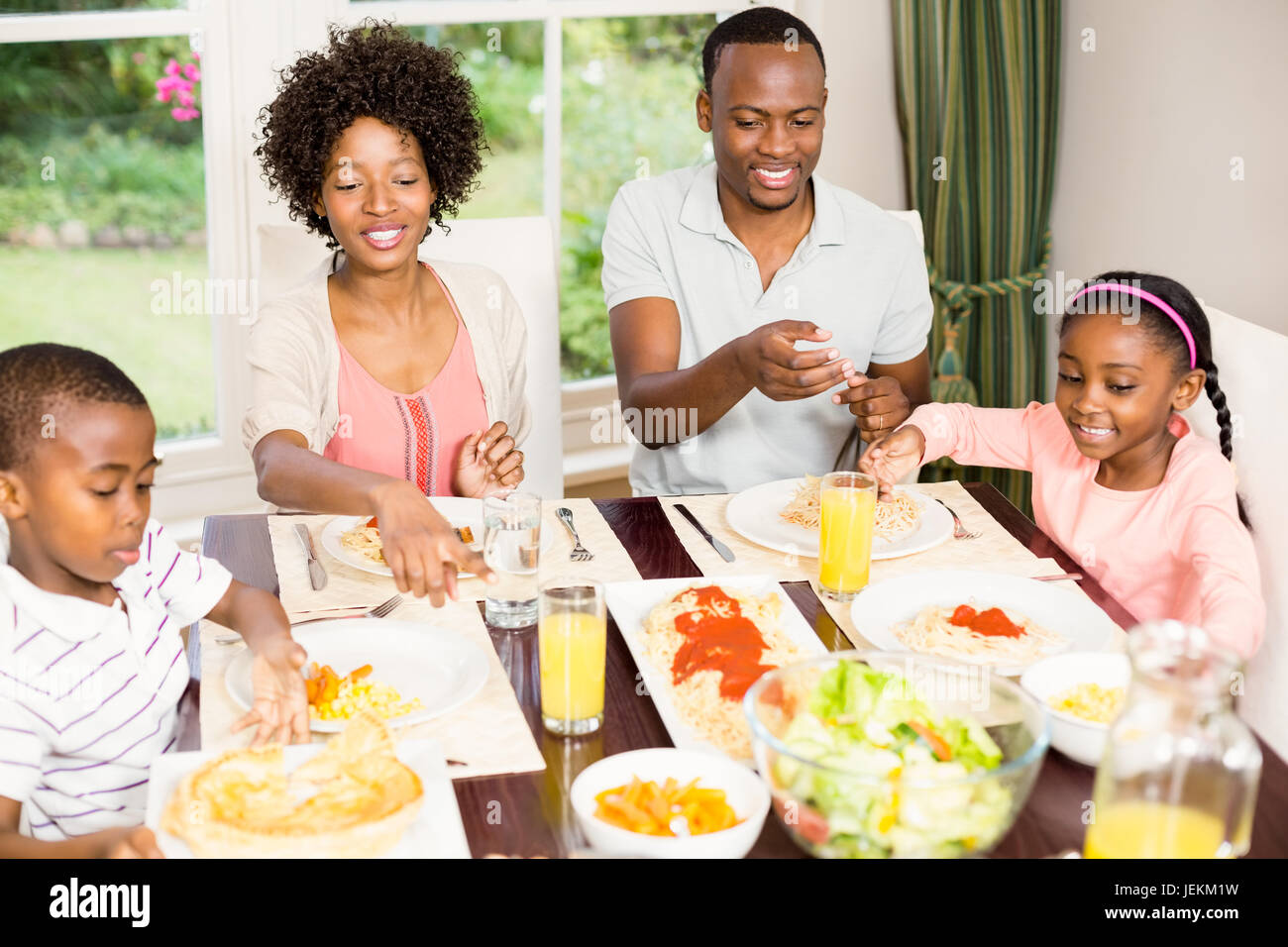 Happy family eating together Stock Photo - Alamy