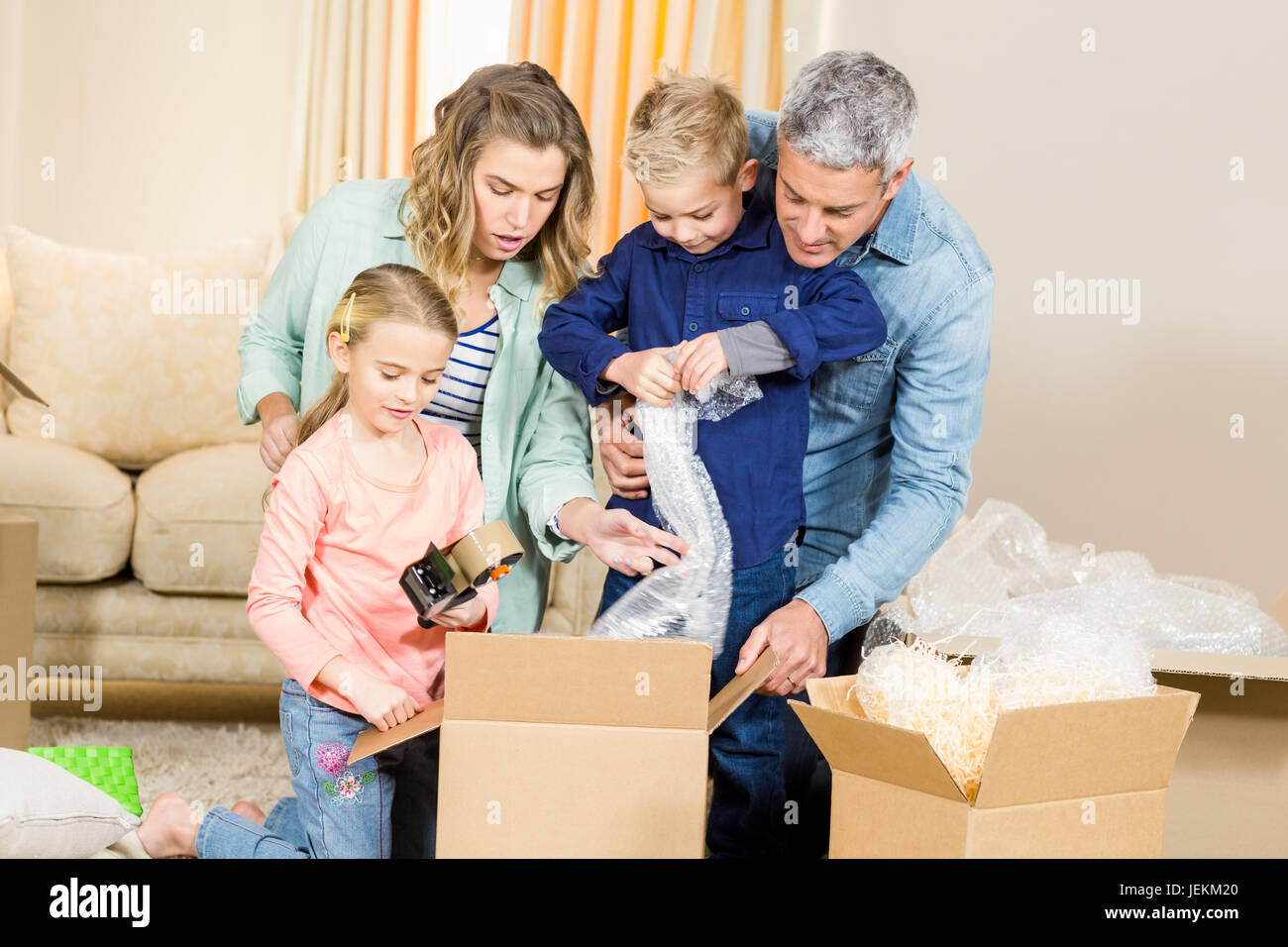 Portrait of happy family opening boxes Stock Photo - Alamy