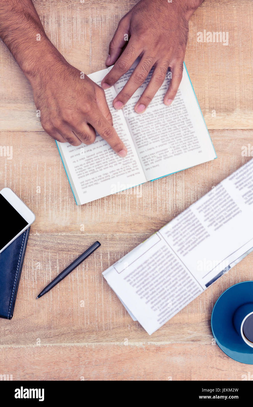 Man reading book on table Stock Photo - Alamy