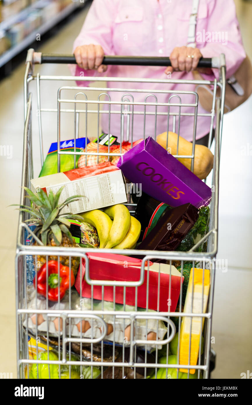 Senior woman pushing full cart Stock Photo - Alamy