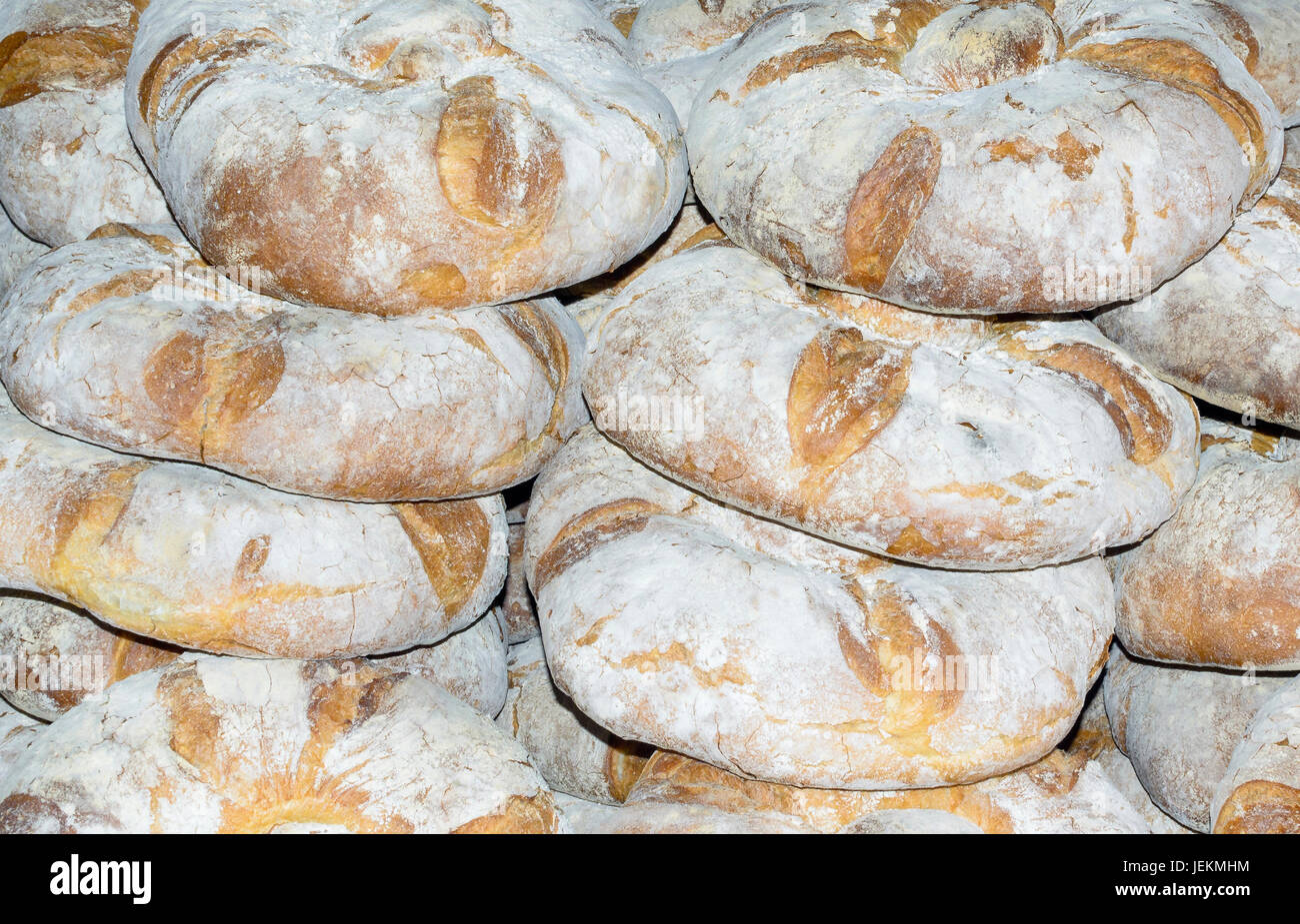 Big round breads for sale, at a medieval bakery stall. Flour over them ...