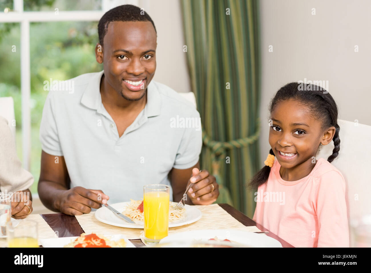 Happy family enjoying their meal Stock Photo - Alamy
