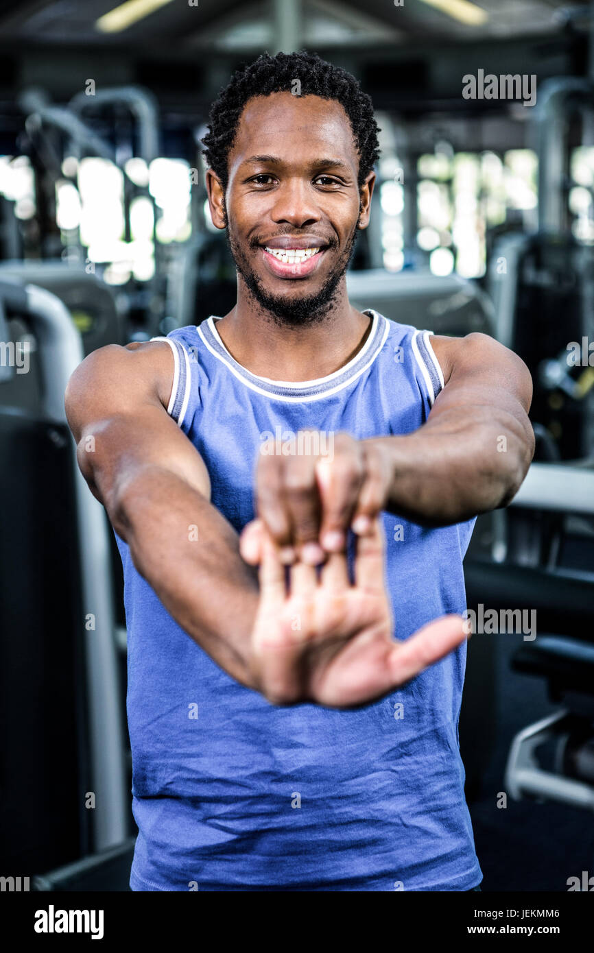 Smiling muscular man stretching arms Stock Photo - Alamy