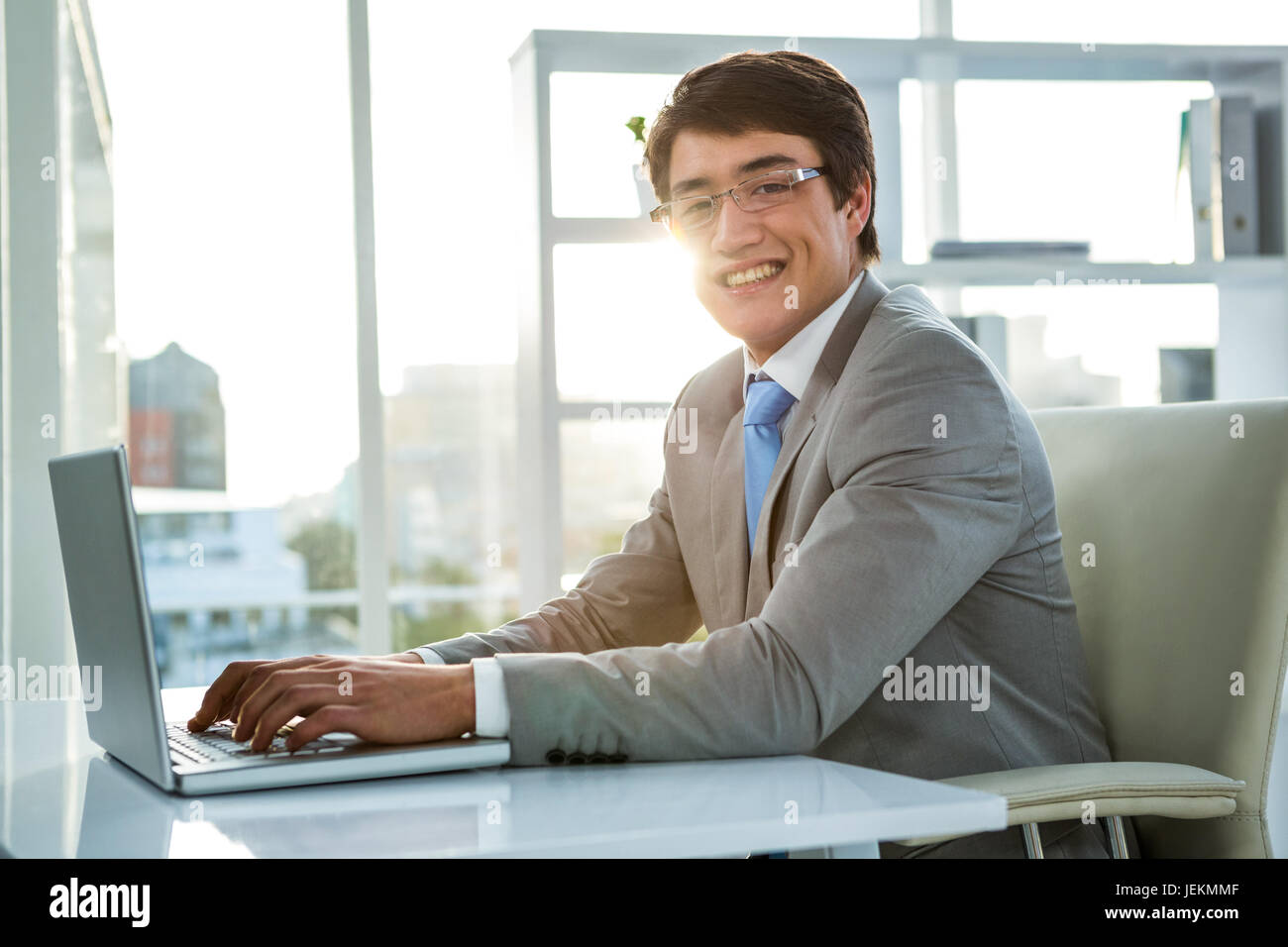 Smiling businessman using his computer Stock Photo - Alamy