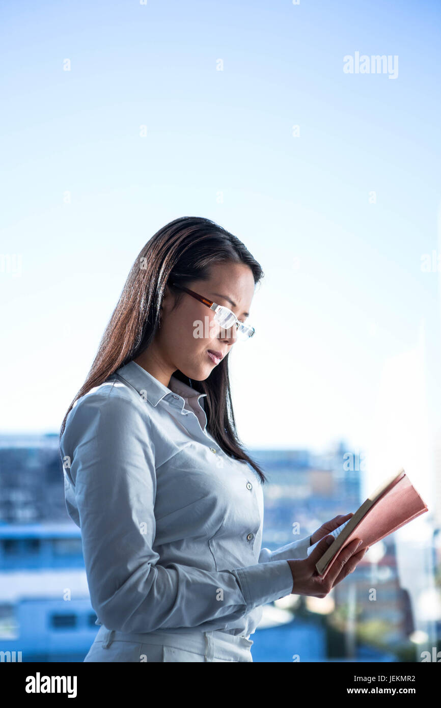 Concentrated businesswoman reading book Stock Photo - Alamy
