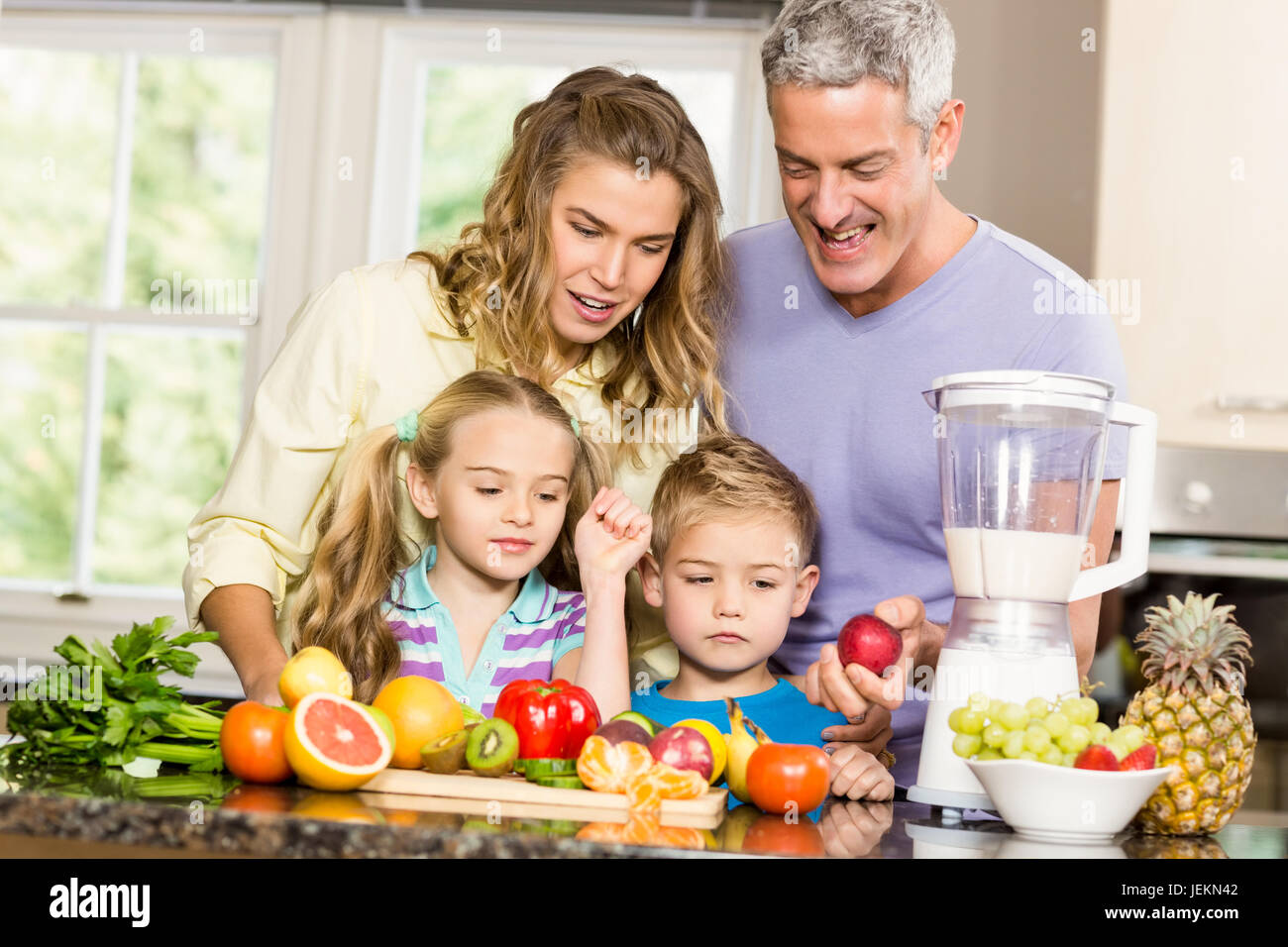 Happy family preparing healthy smoothie Stock Photo - Alamy