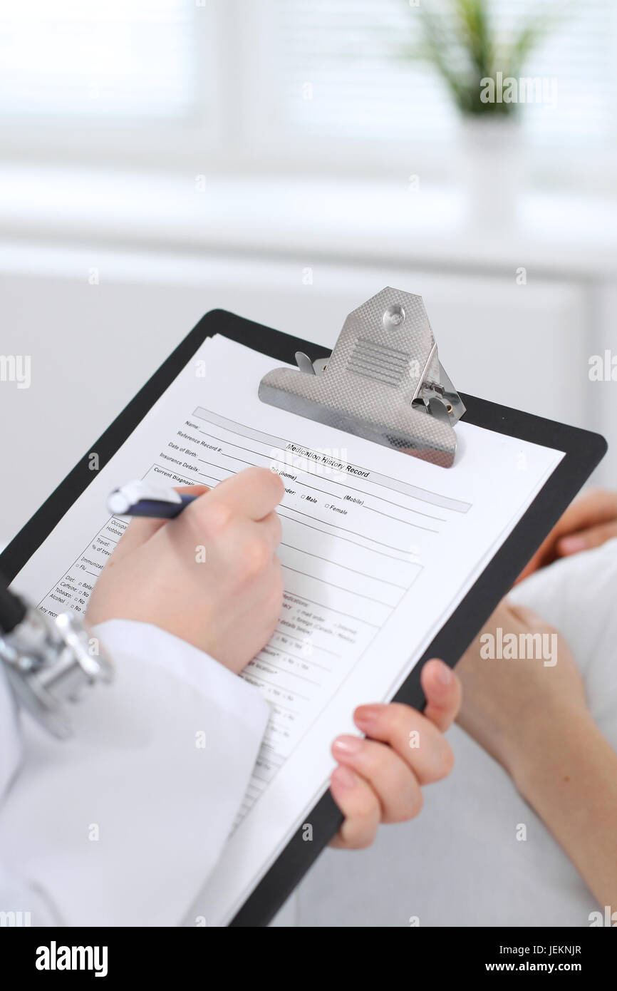 Close-up of a female doctor holding application form while consulting ...