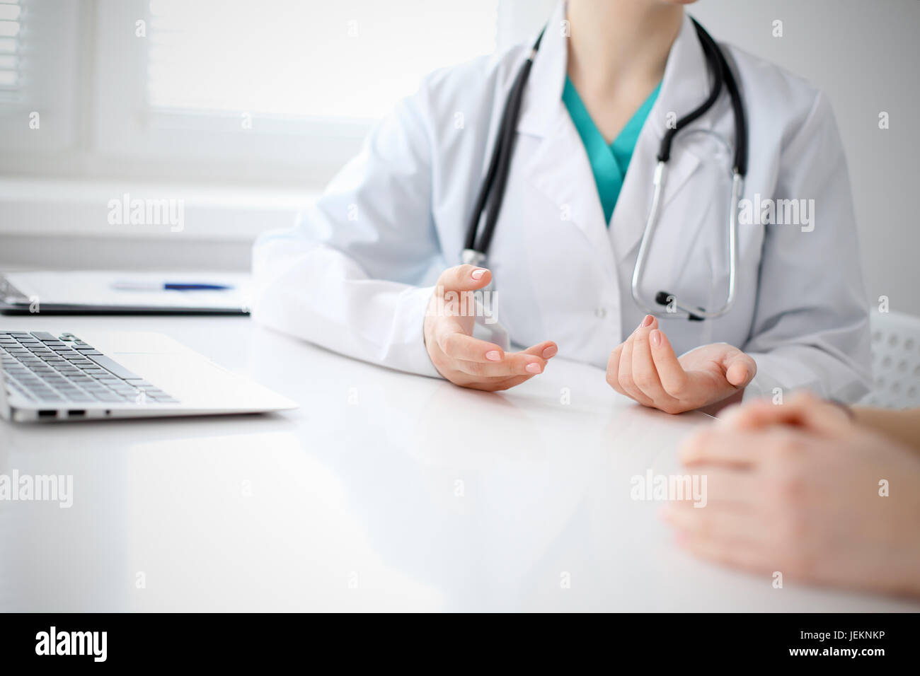 Doctor and patient are discussing something, just hands at the table ...