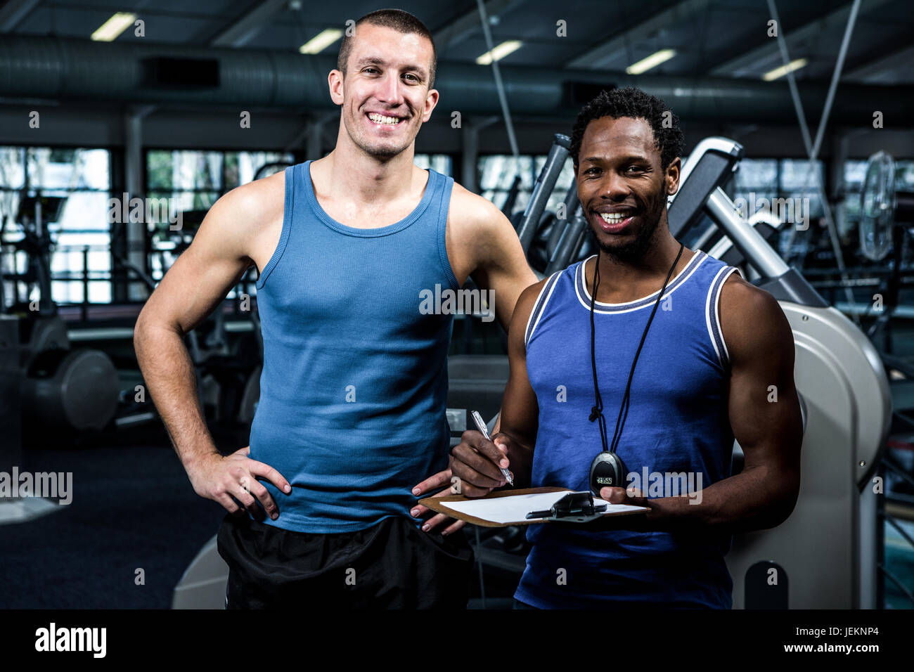 Muscular man with trainer smiling at camera Stock Photo - Alamy