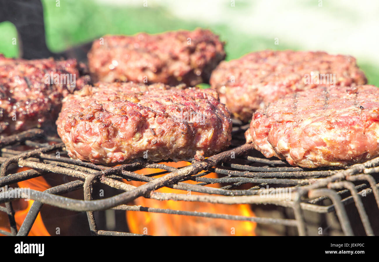 Top view of burger chops preparing on grill on countryside backgrond ...
